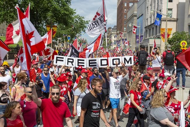 Protesters march for freedom as much larger crowds celebrate Canada Day ...